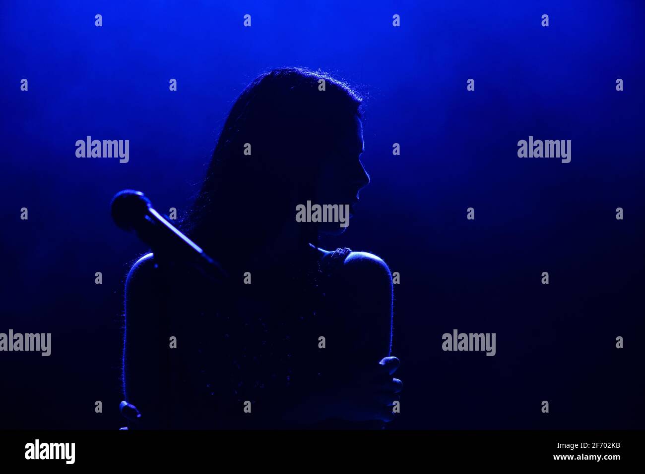 Portrait of beautiful singing woman on dark background Stock Photo - Alamy