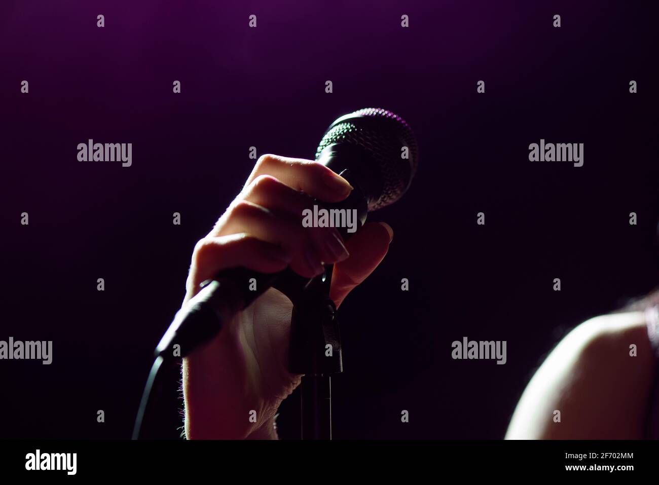 Microphone in hand singer on the stage Stock Photo - Alamy