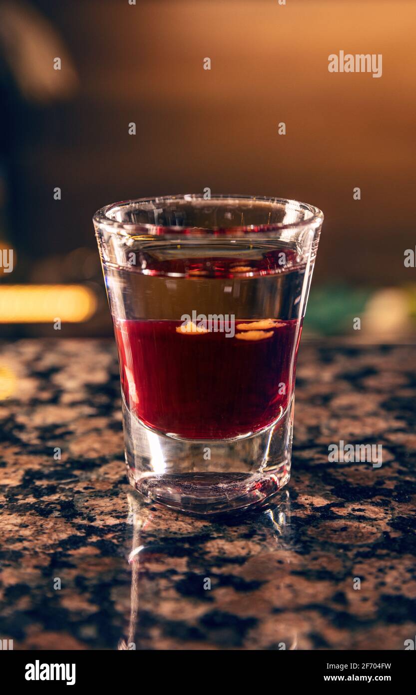 Red two layered cocktail in shot glass at the bar counter Stock Photo ...