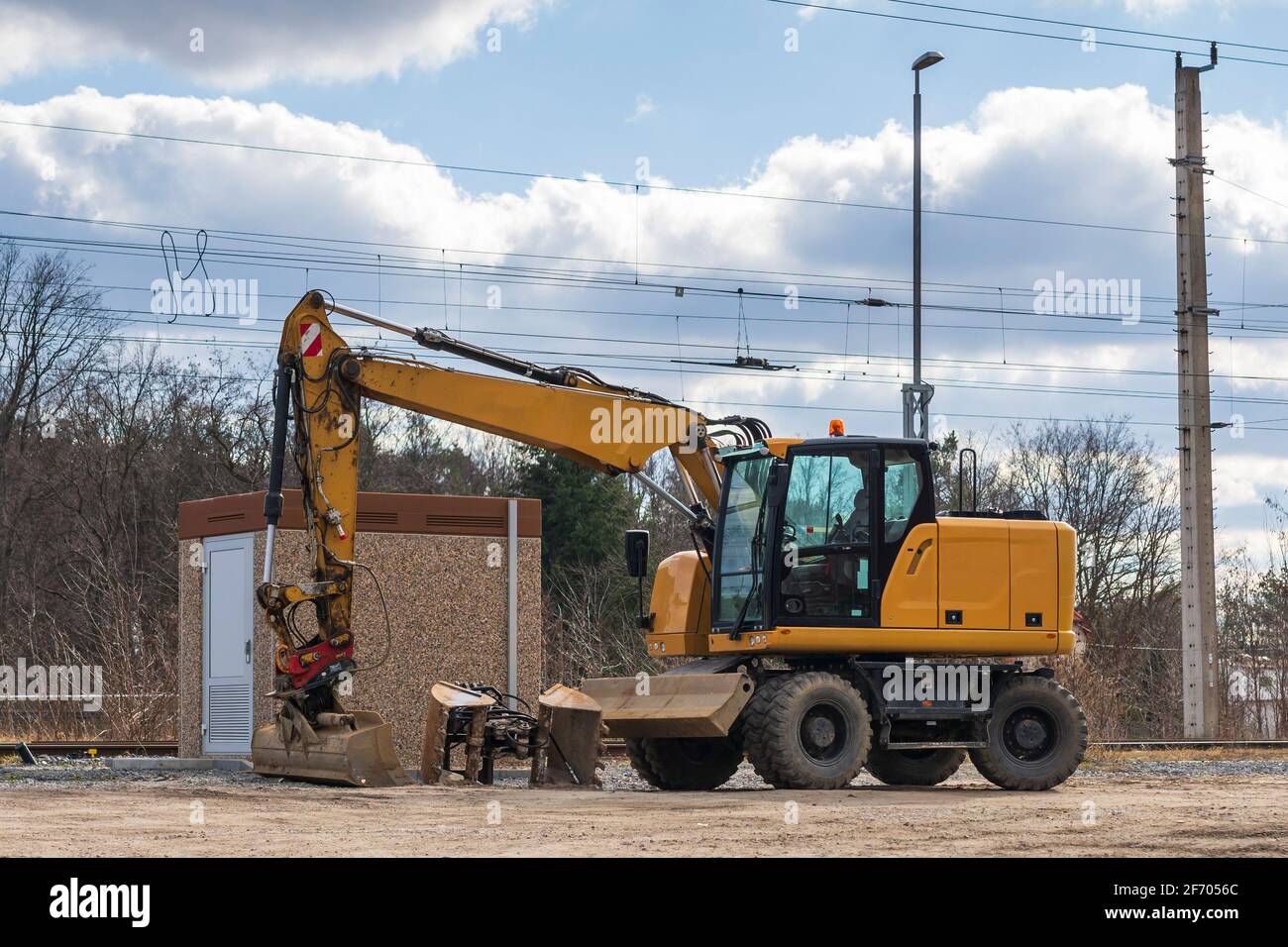 An excavator stands next to railroad tracks Stock Photo - Alamy