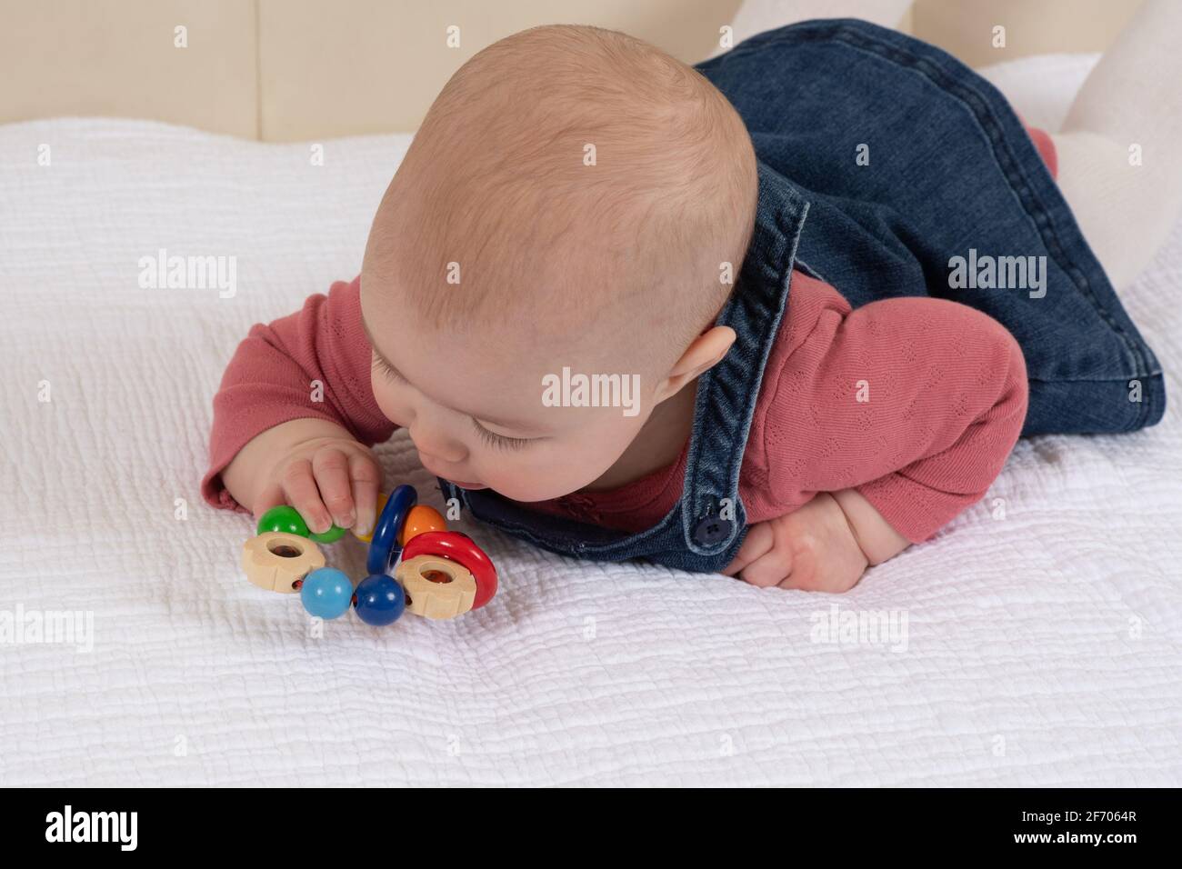 4 month old baby girl on stomach reaching for toy, grasping toy Stock ...