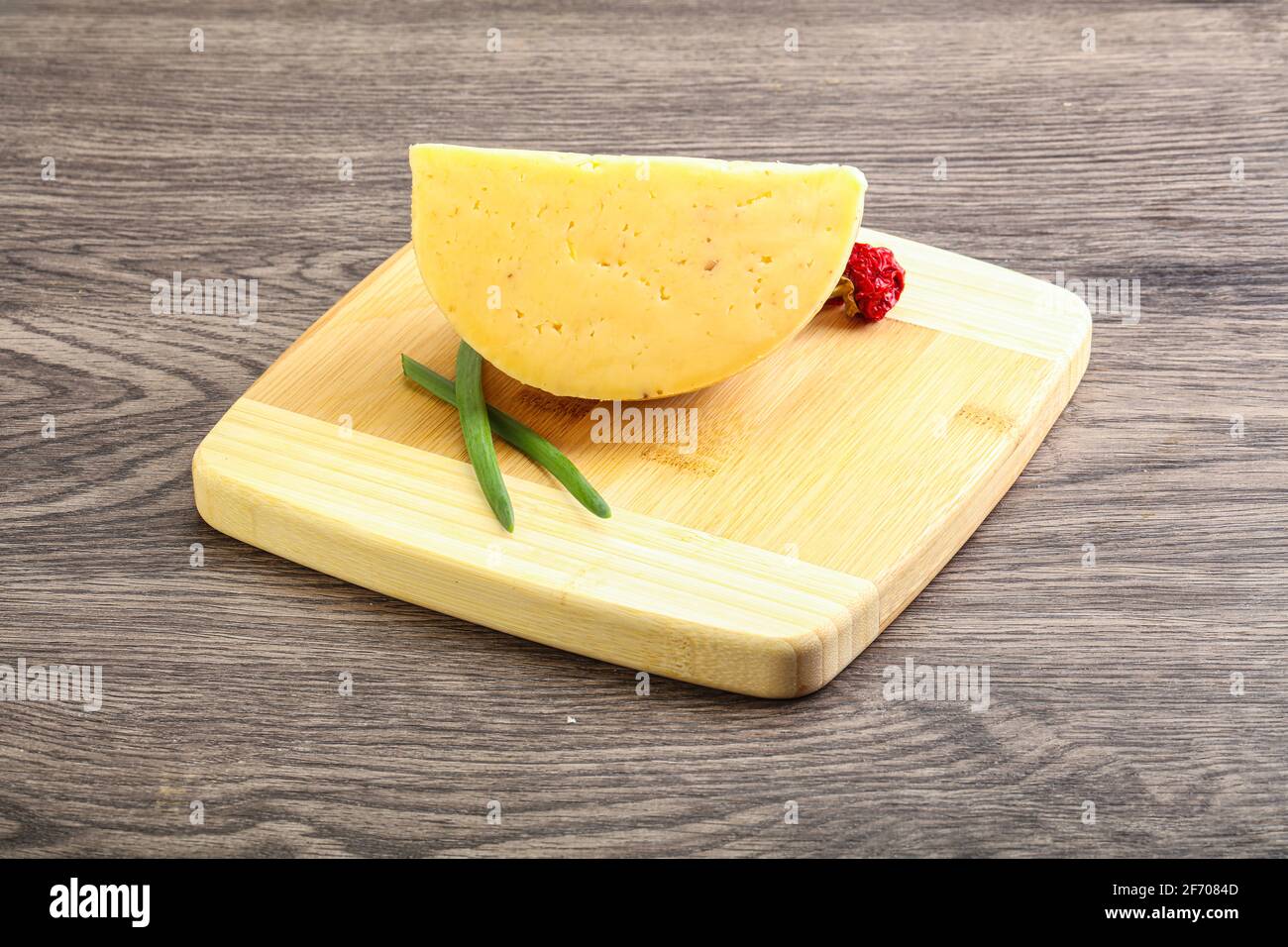 Hard cheese brick with walnut over board Stock Photo - Alamy