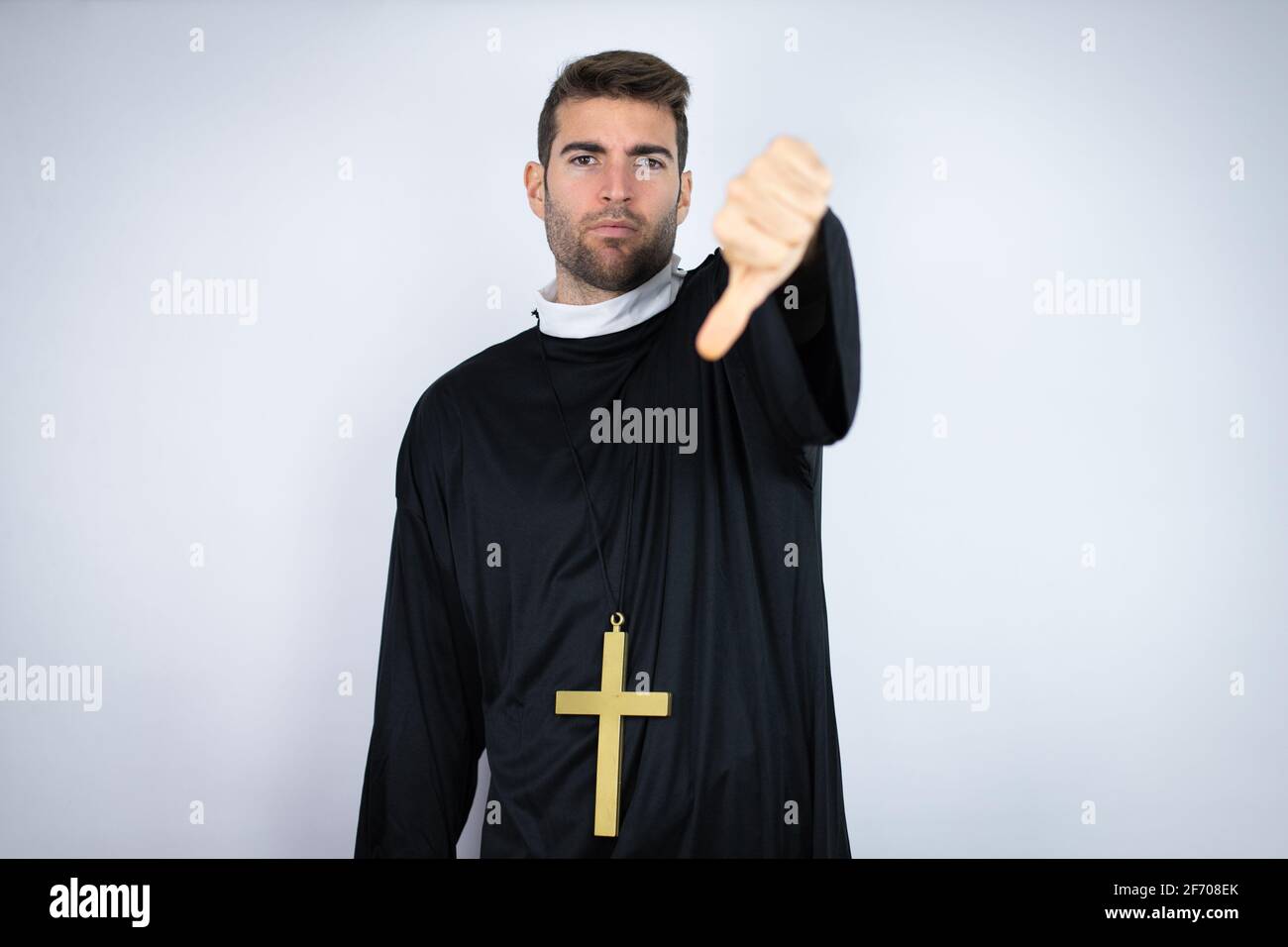 Young hispanic man wearing priest uniform standing over white ...