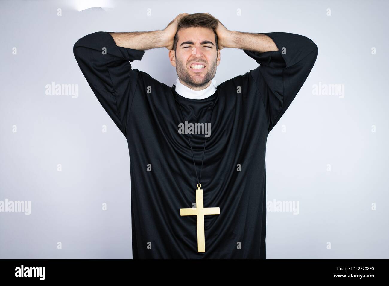 Young hispanic man wearing priest uniform standing over white ...