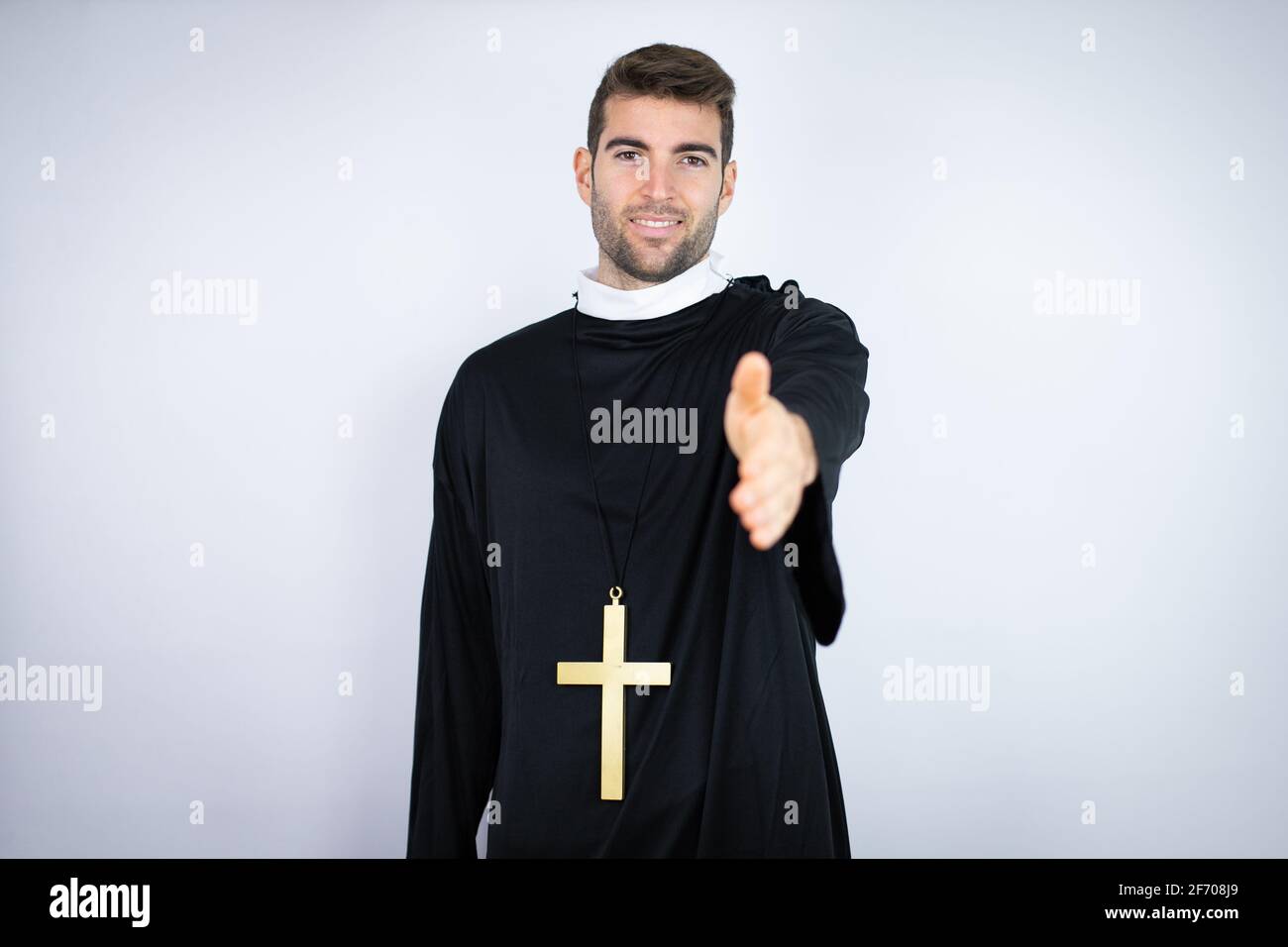 Young hispanic man wearing priest uniform standing over white ...