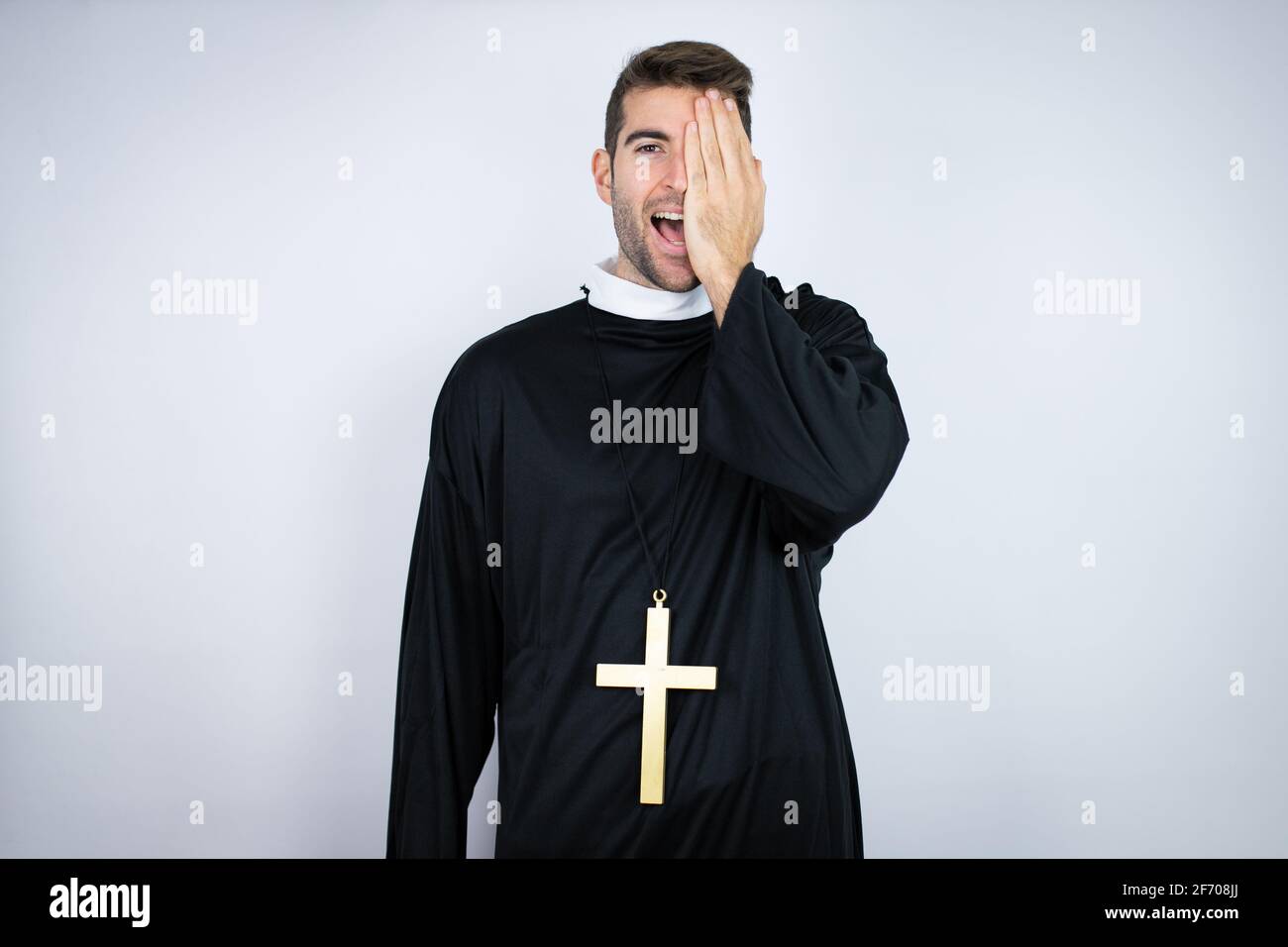 Young hispanic man wearing priest uniform standing over white ...