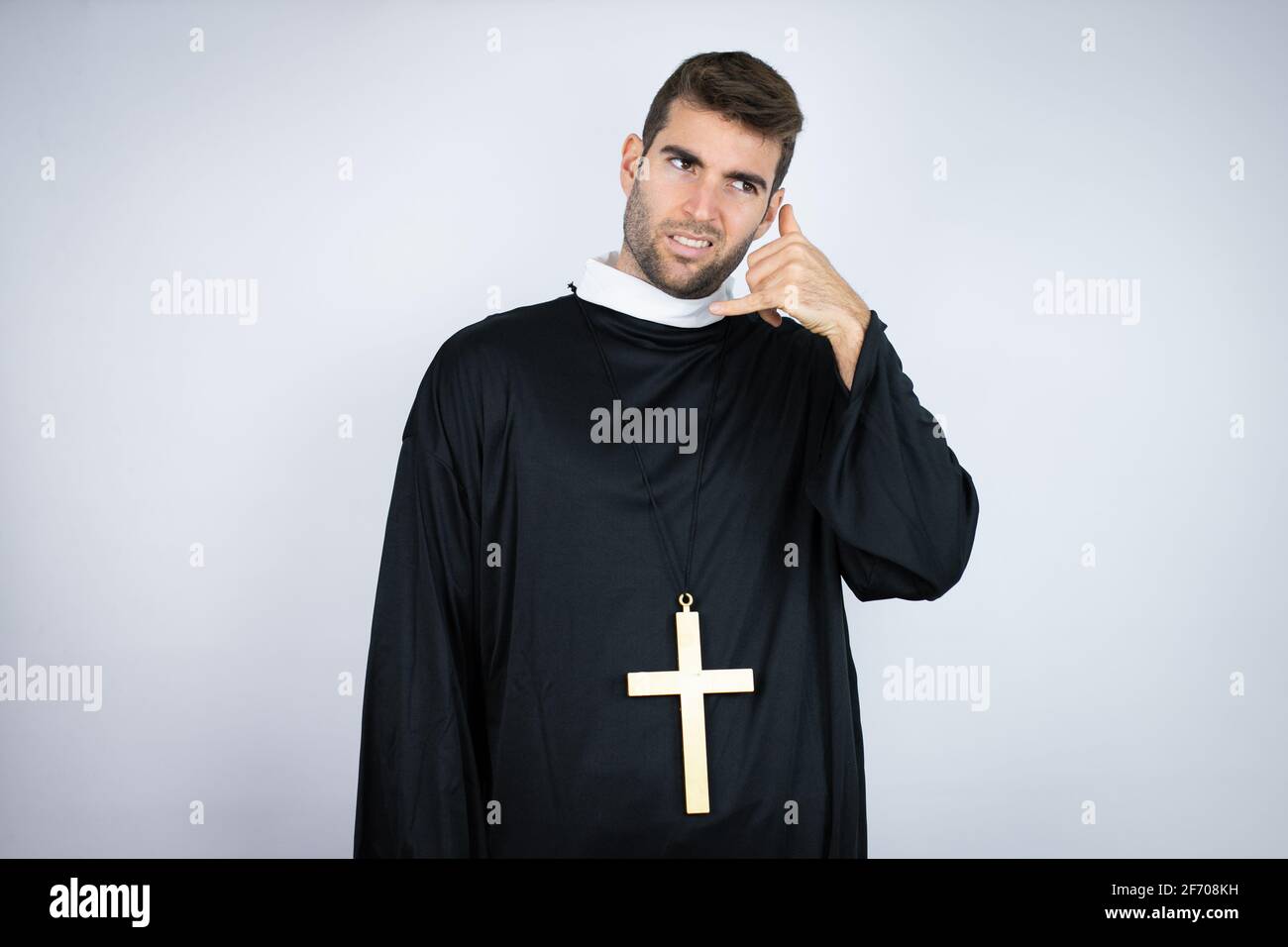 Young hispanic man wearing priest uniform standing over white ...