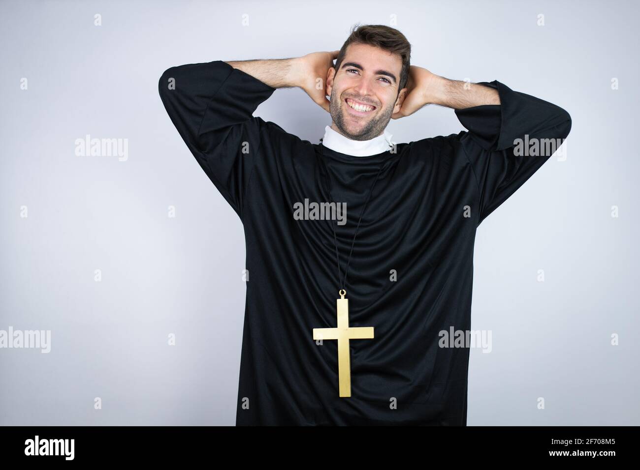 Young hispanic man wearing priest uniform standing over white ...