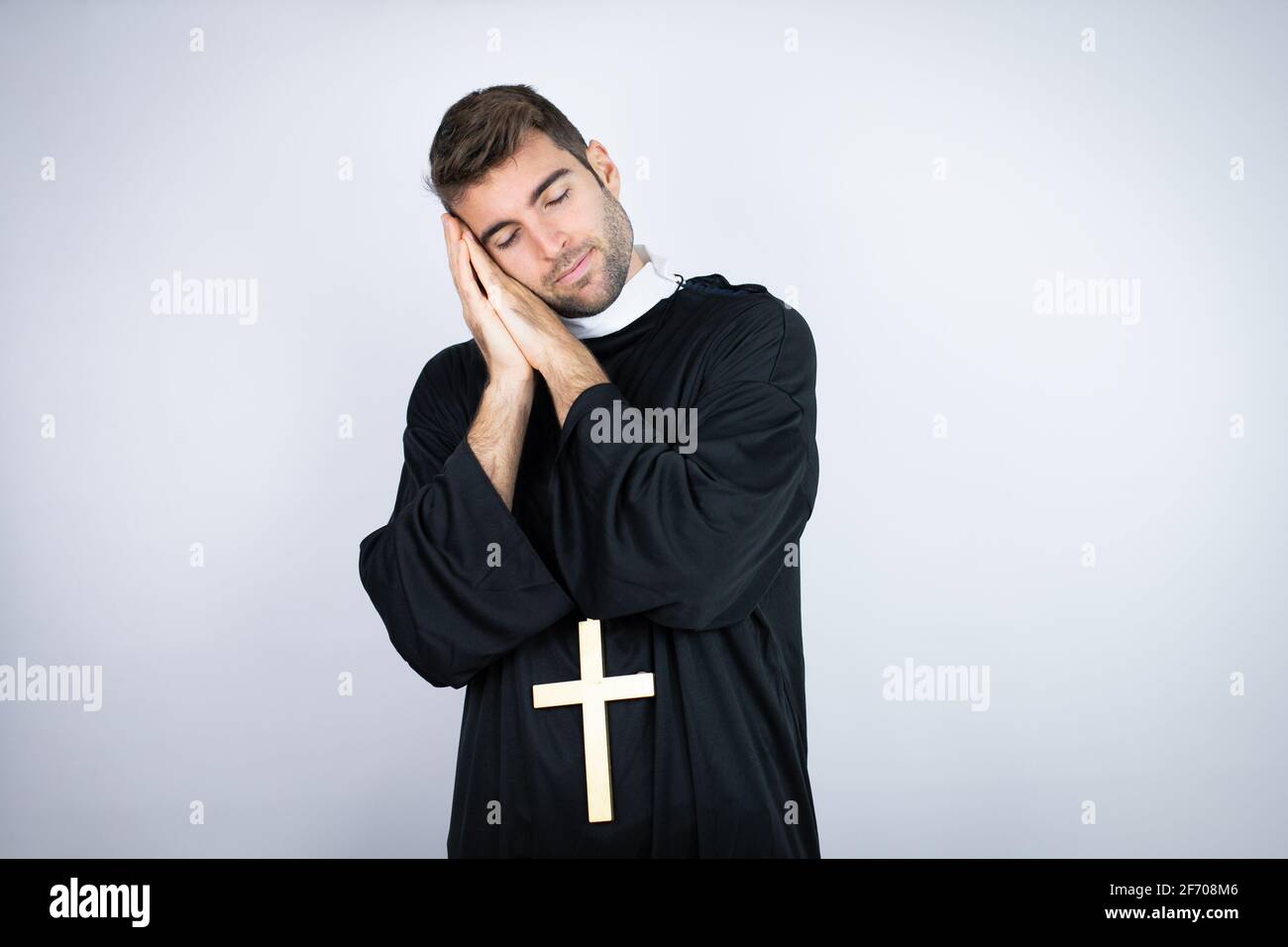 Young hispanic man wearing priest uniform standing over white ...