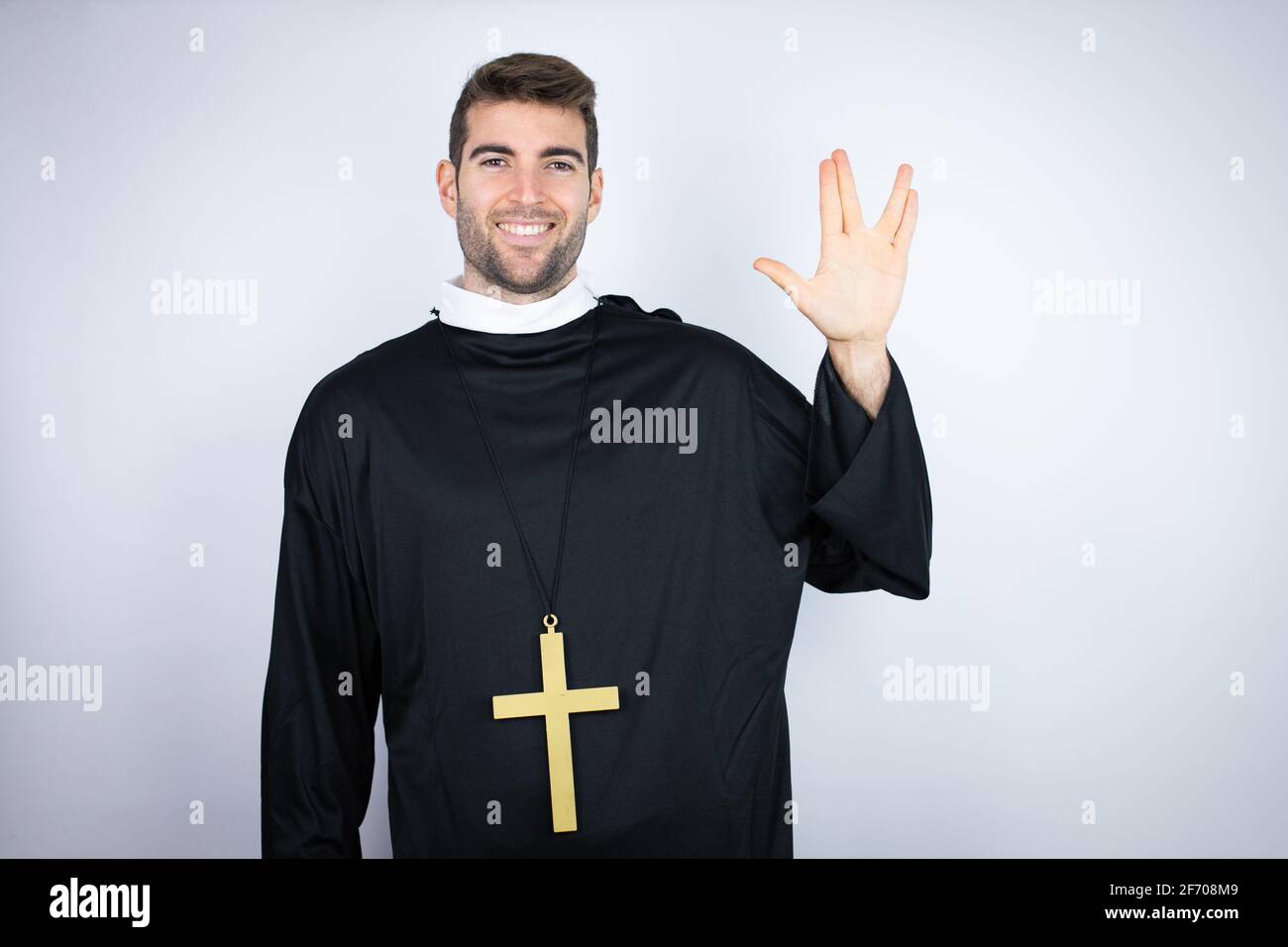 Young hispanic man wearing priest uniform standing over white ...
