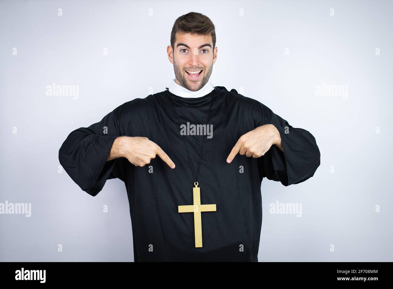 Young hispanic man wearing priest uniform standing over white ...