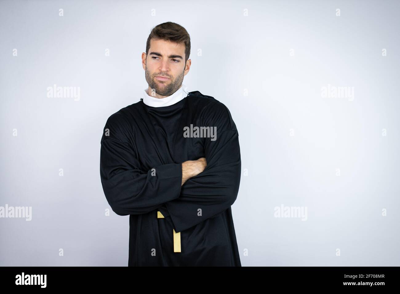 Young hispanic man wearing priest uniform standing over white ...