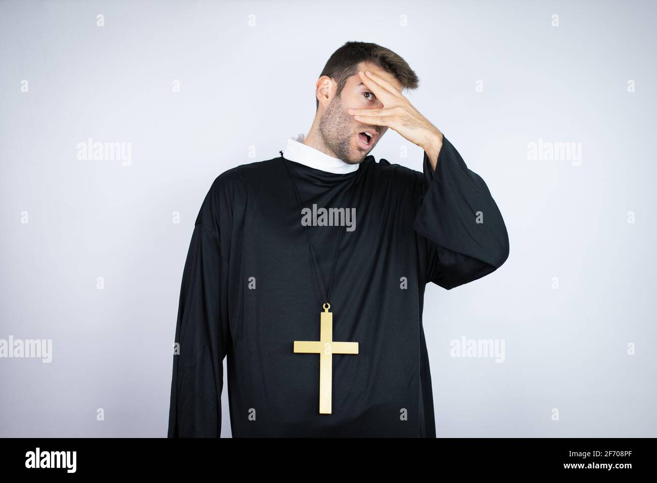 Young hispanic man wearing priest uniform standing over white ...