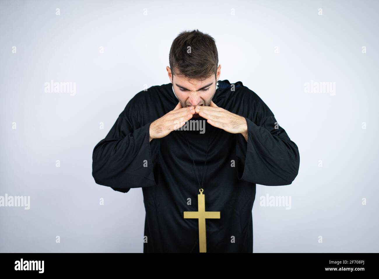 Young hispanic man wearing priest uniform standing over white ...