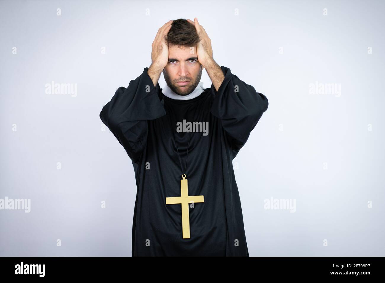Young hispanic man wearing priest uniform standing over white ...