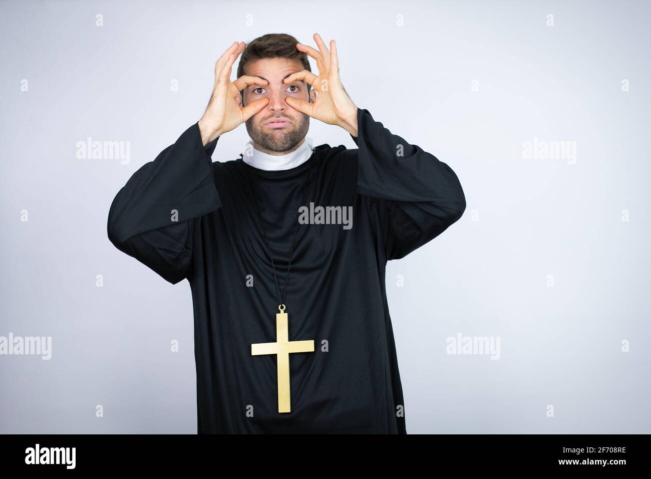 Young hispanic man wearing priest uniform standing over white ...