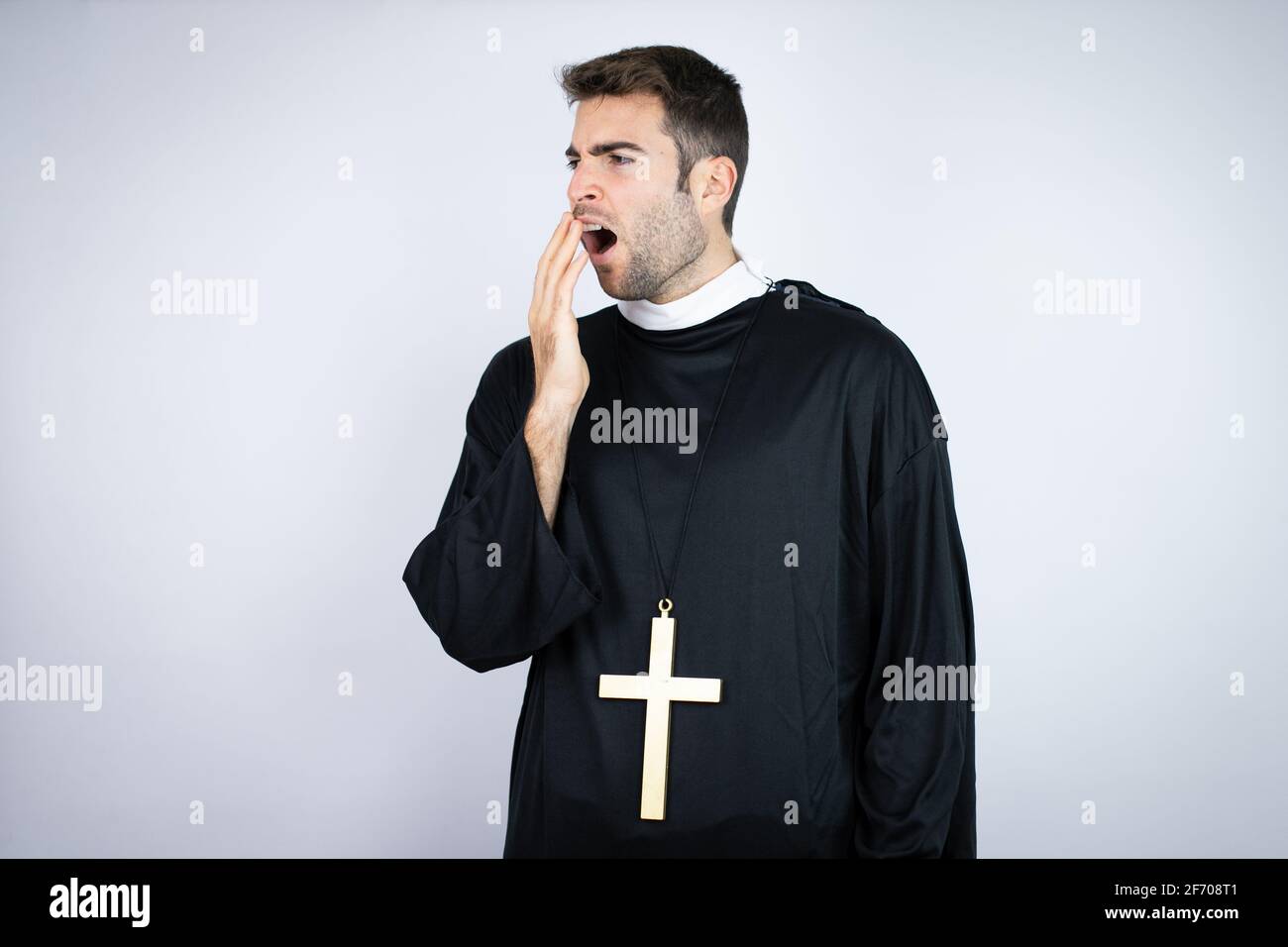 Young hispanic man wearing priest uniform standing over white ...