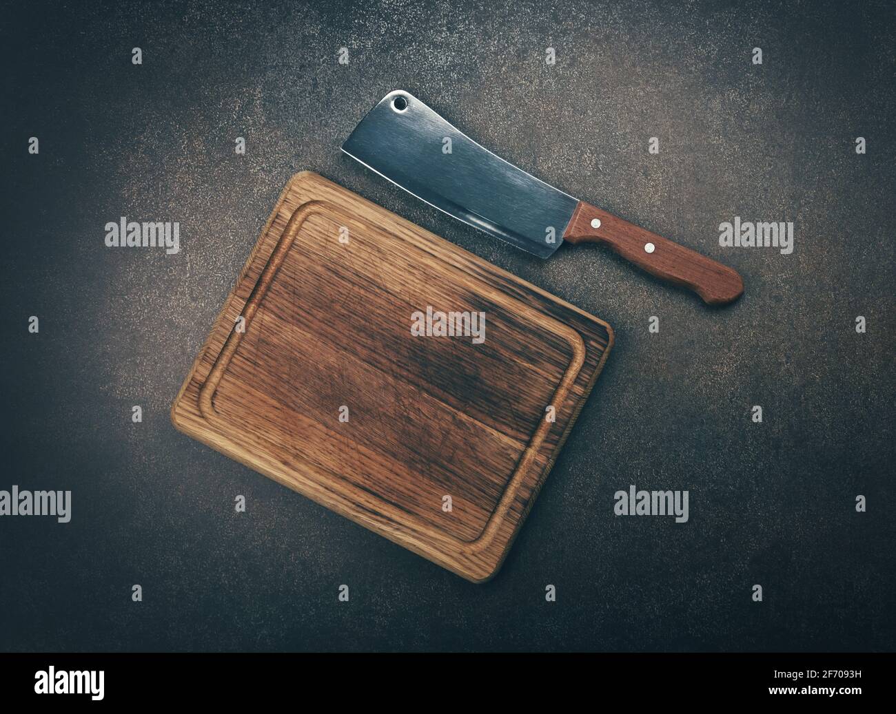 Close up one butcher metal meat cleaver and oak wood chopping board on ...