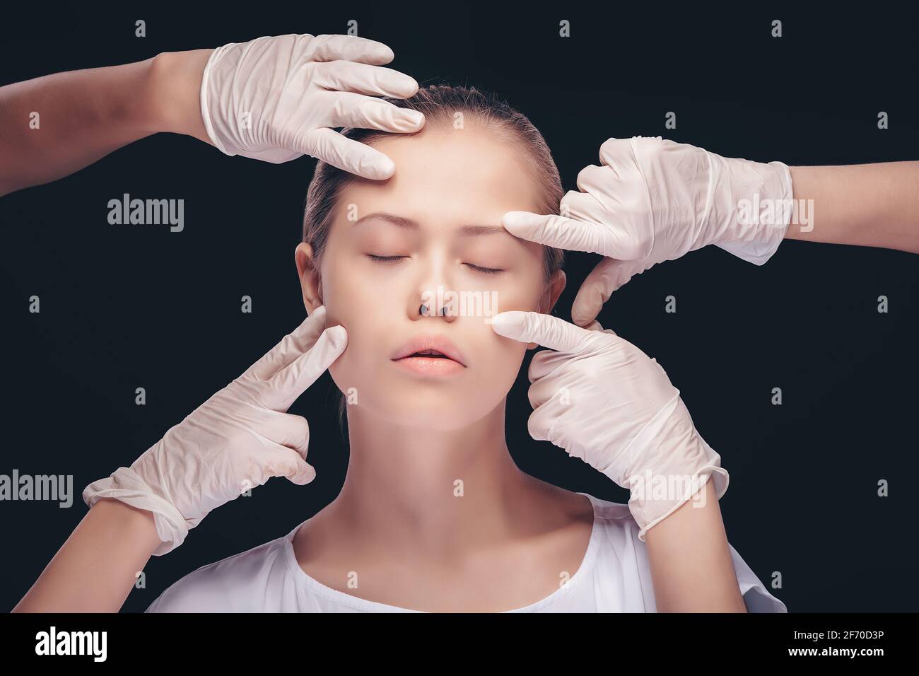 Young woman with eyes closed having an medical exam of her face skin by ...