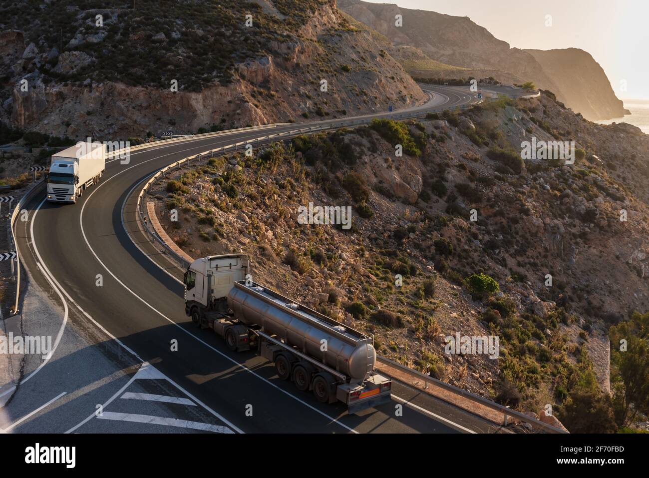 Two trucks on a mountain road with a two-way traffic crossing Stock ...