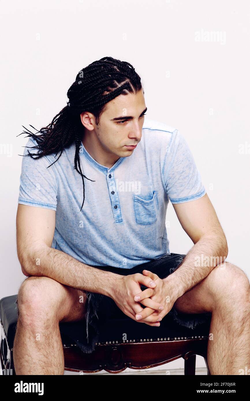 Stylish male model with afro braids posing in studio on isolated ...