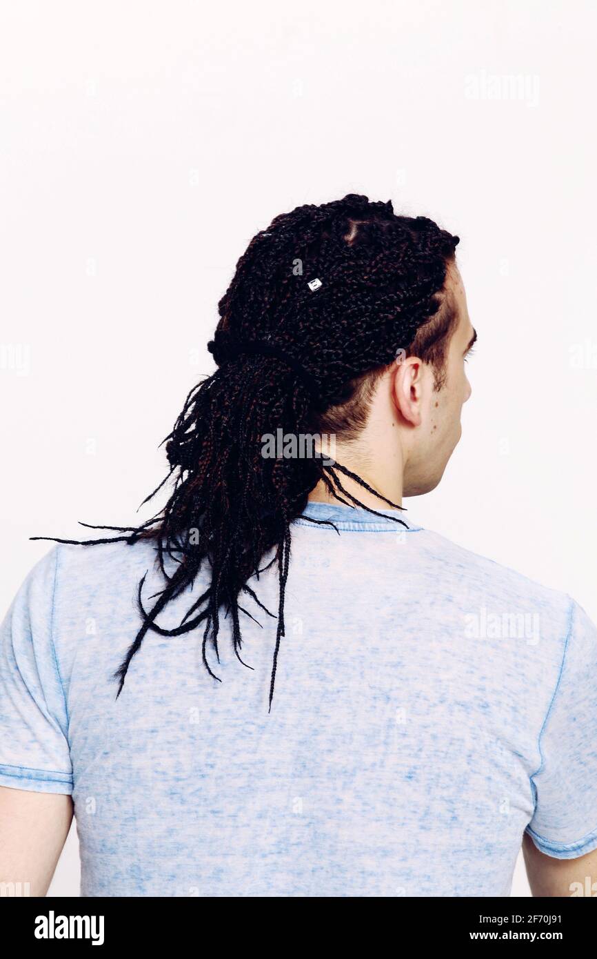 Stylish male model with afro braids posing in studio on isolated ...