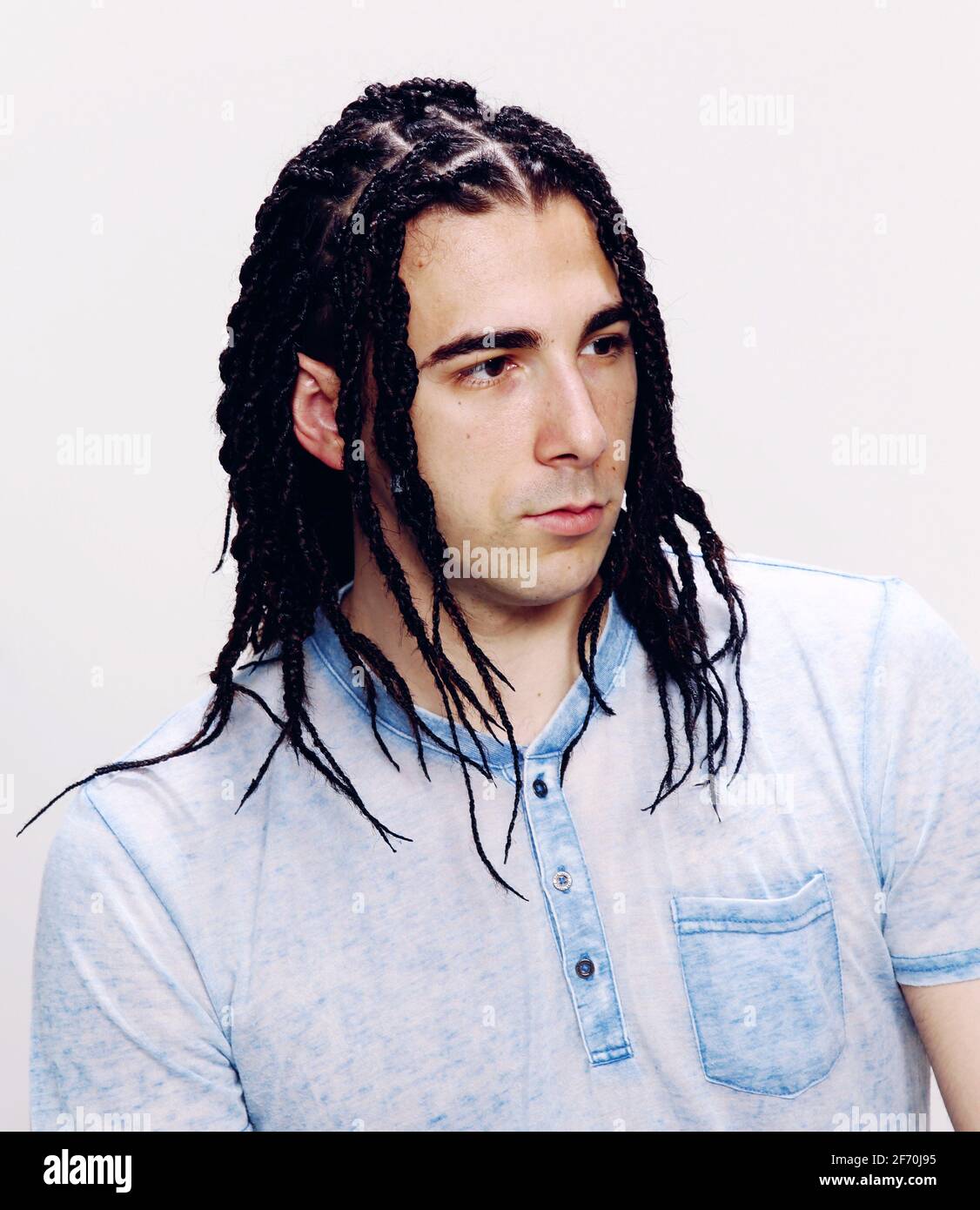 Stylish male model with afro braids posing in studio on isolated ...