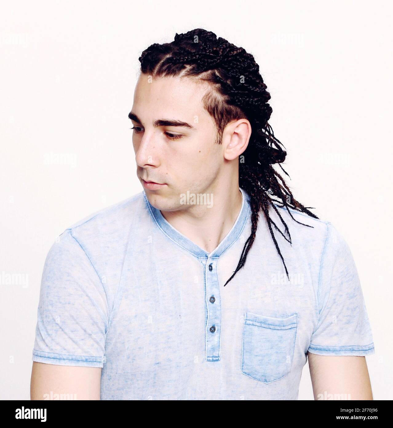 Stylish male model with afro braids posing in studio on isolated ...