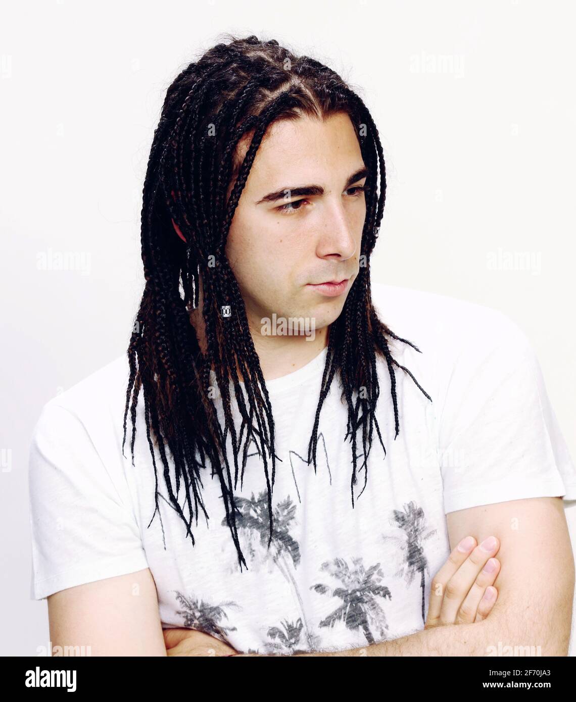 Stylish male model with afro braids posing in studio on isolated ...