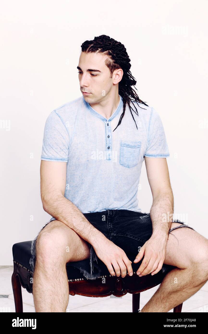 Stylish male model with afro braids posing in studio on isolated ...