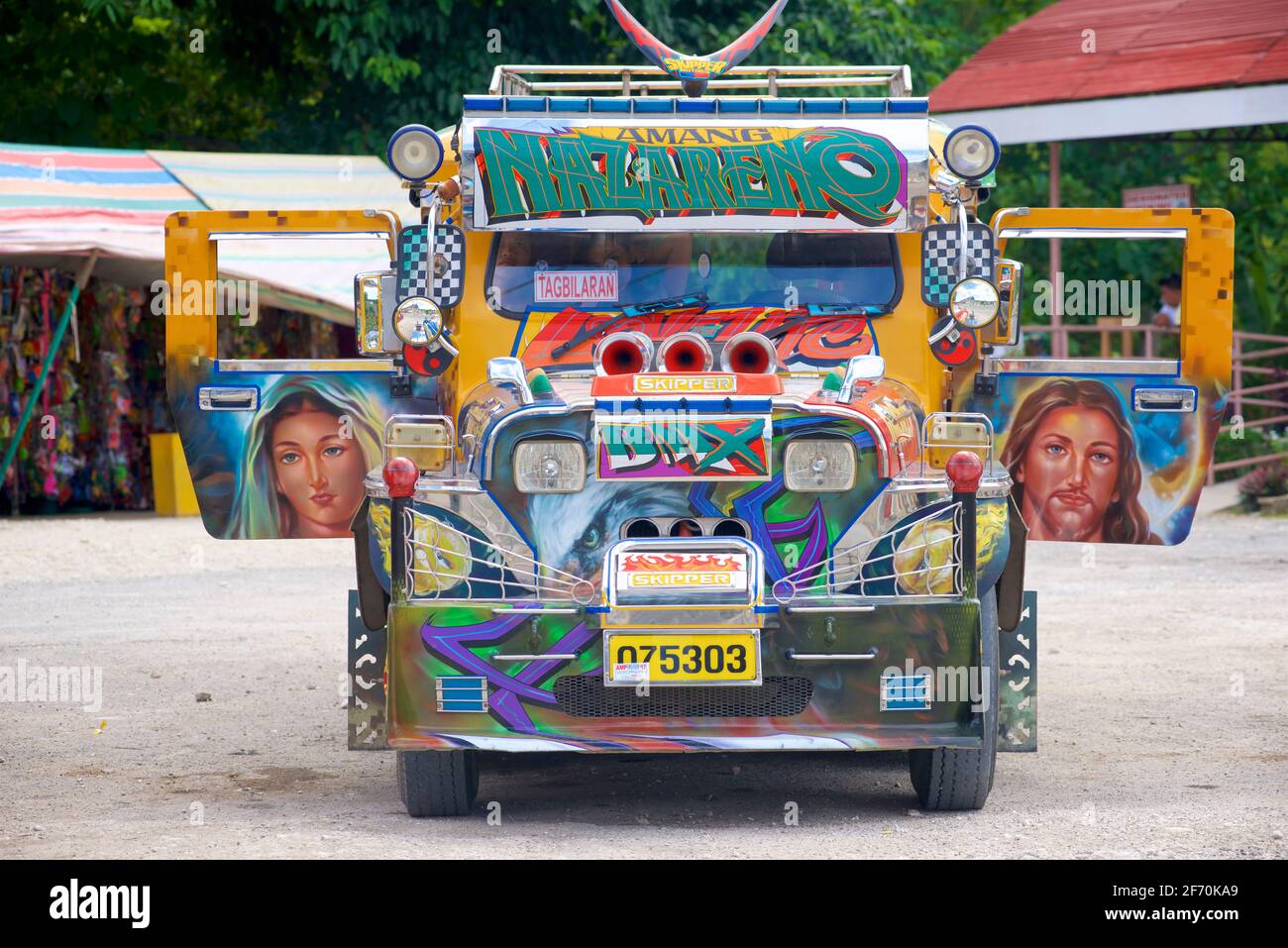 Filipino Jeepney, decorated with painted images of Jesus Christ and ...