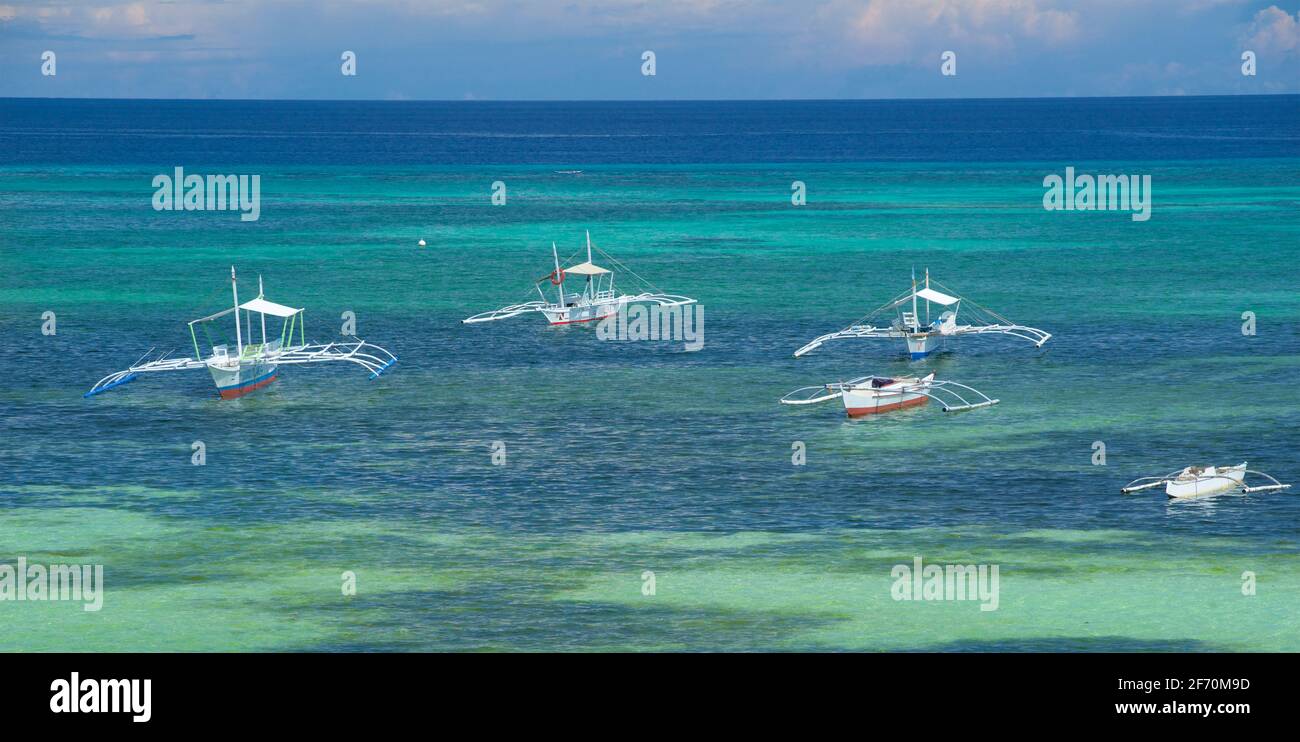 A fleet of outrigger canoes anchored off Doljo beach, Panglao Island ...