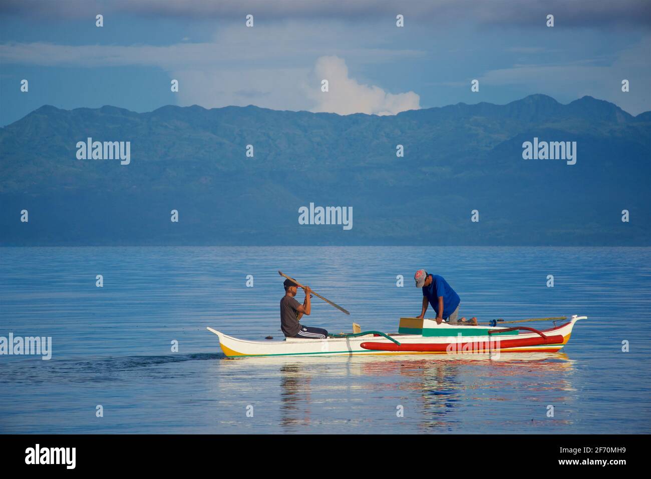 Filipino fishermen preparing to take their outrigger canoes out to fish ...