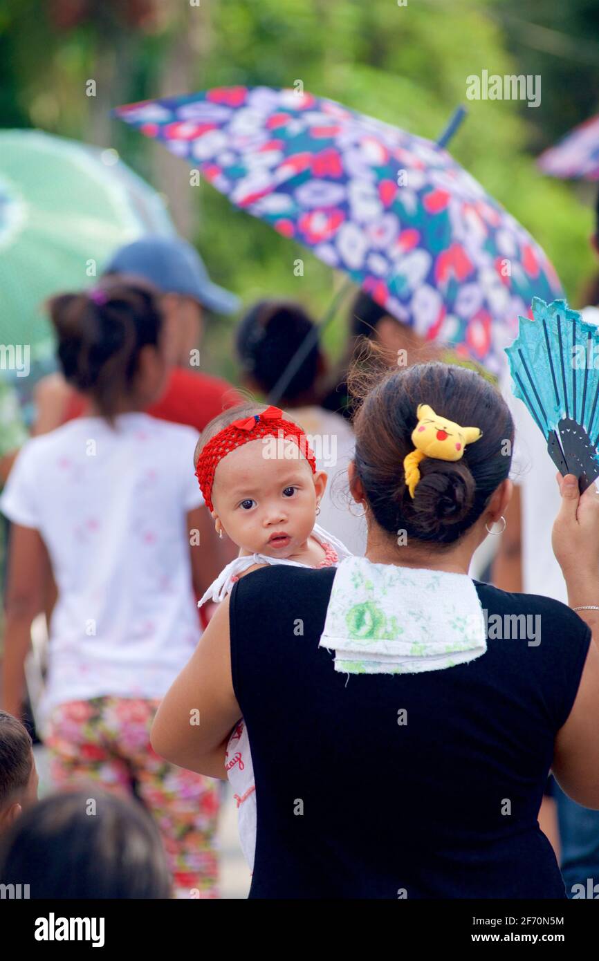 Filipina mother carrying her baby in a procession for Flores de Mayo ...