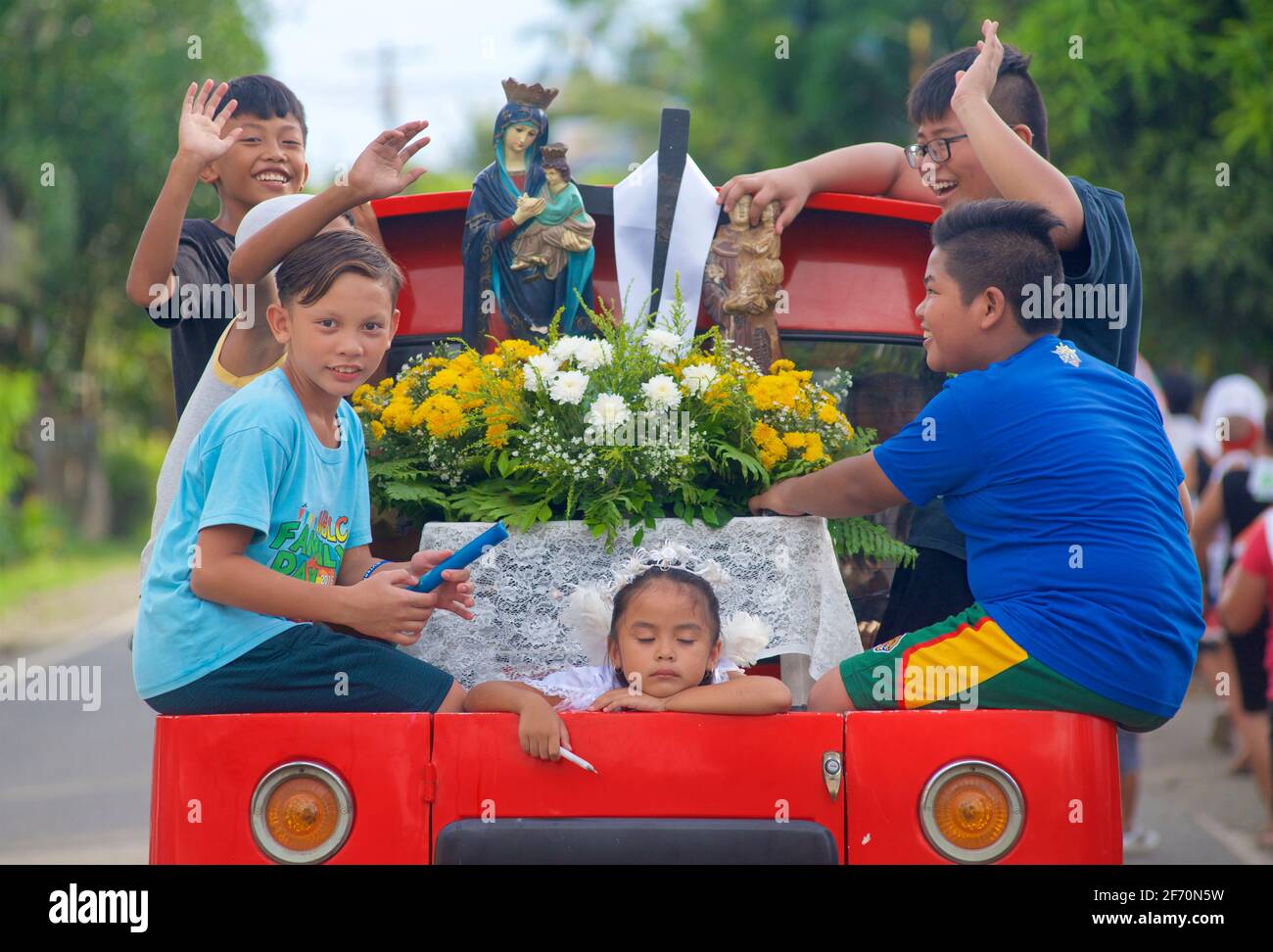 Float on the back of a pickup with children and images of saints for ...