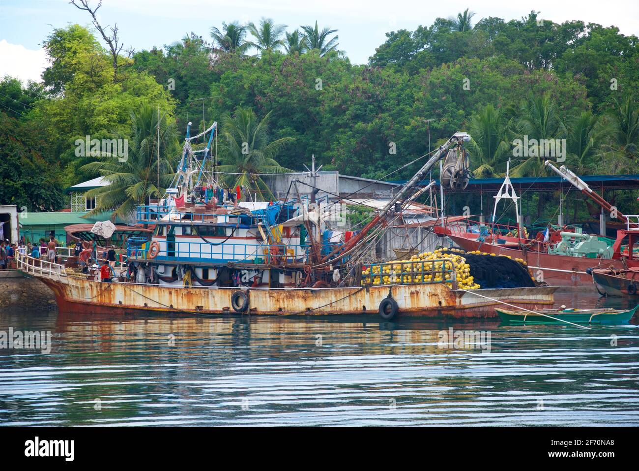 Fishing boats line the coastal of Punta, Cebu Island. On approach to ...