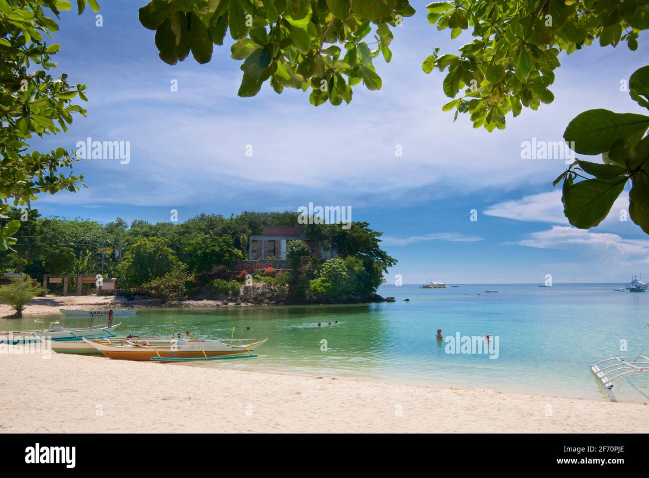 The bay at Logon, Malapascua Island, with outrigger canoes on the white ...