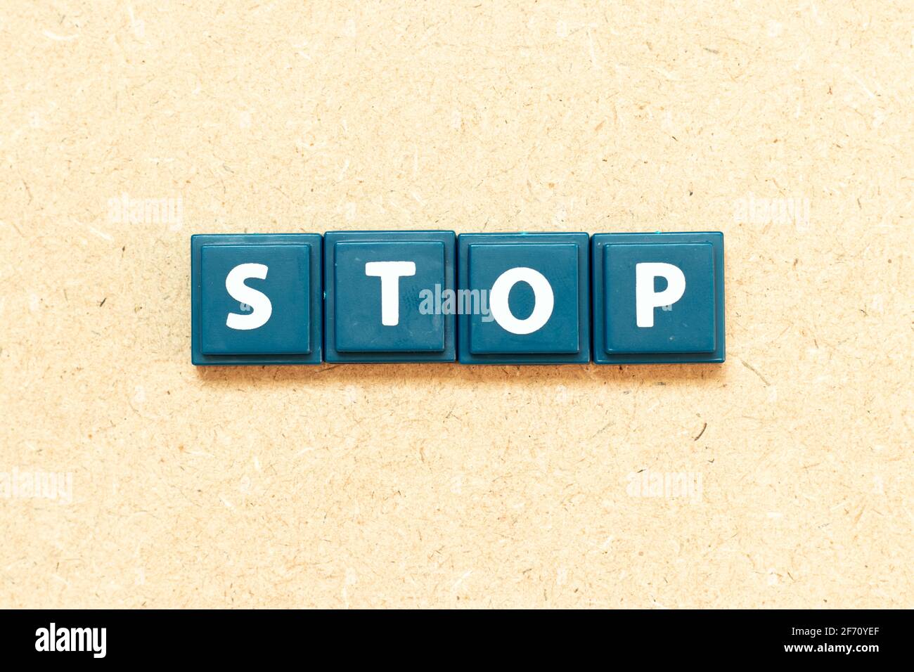 Tile alphabet letter in word stop on wood background Stock Photo - Alamy