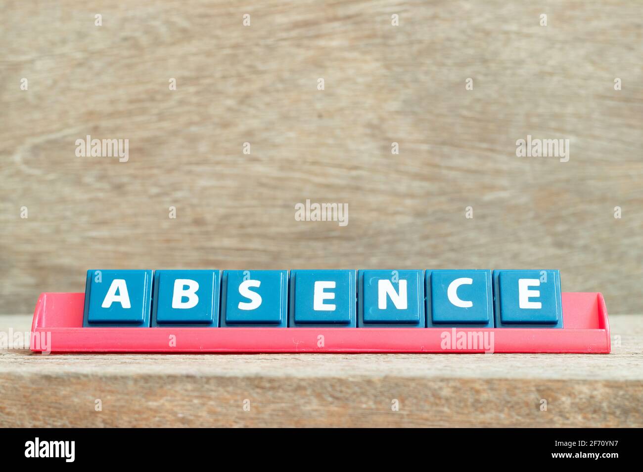Tile alphabet letter with word absence in red color rack on wood ...
