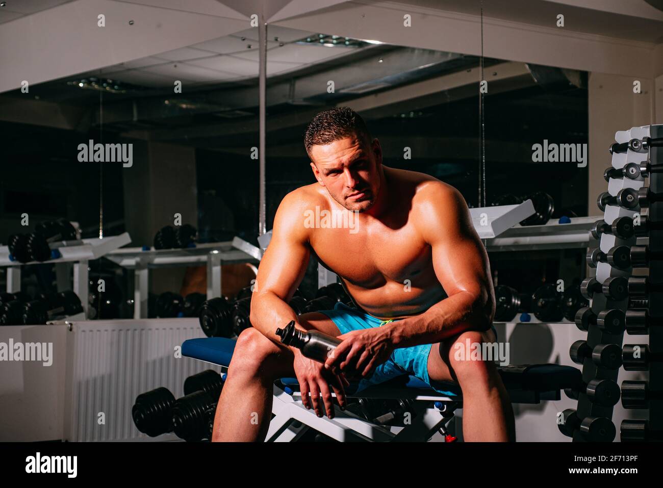 Drink water. Sportsman resting after training at the gym. Stay hydrated ...