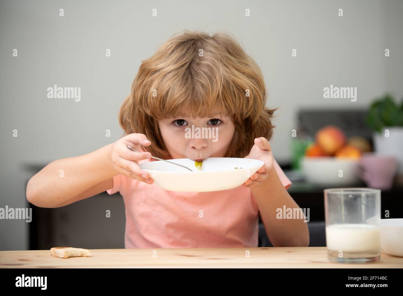 Closeup face of cute little boy eating tasty porridge or cereals with ...