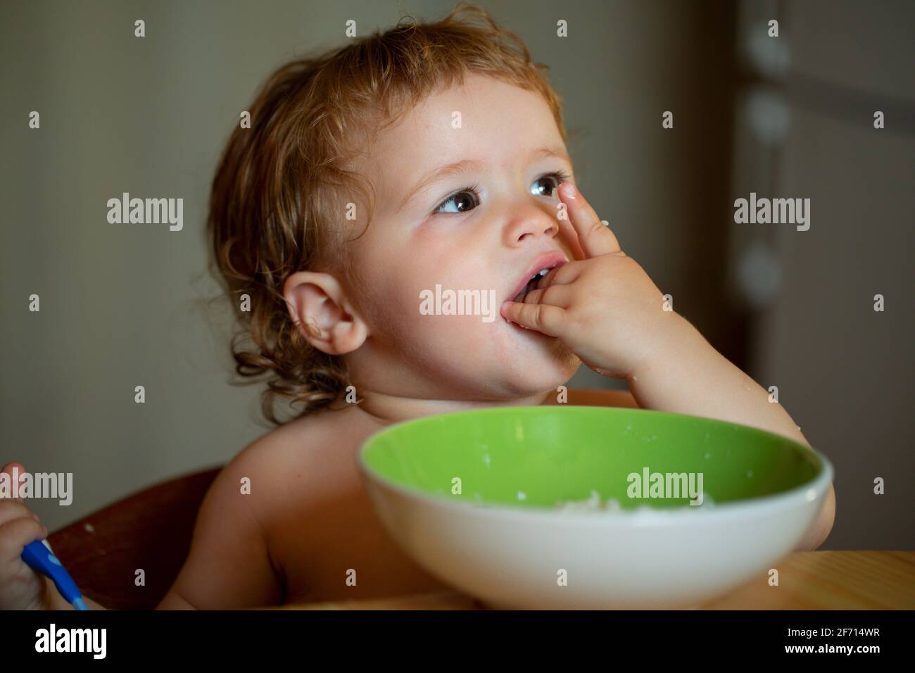Portrait of cute Caucasian child kid with spoon. Hungry messy baby with ...