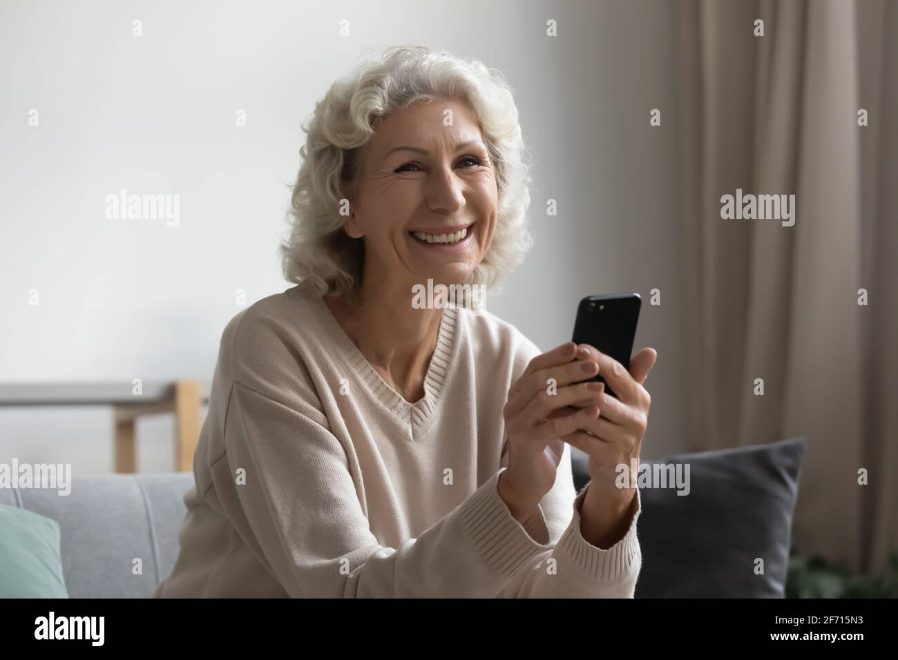 Portrait of happy middle aged female customer holding smartphone Stock Photo - Alamy