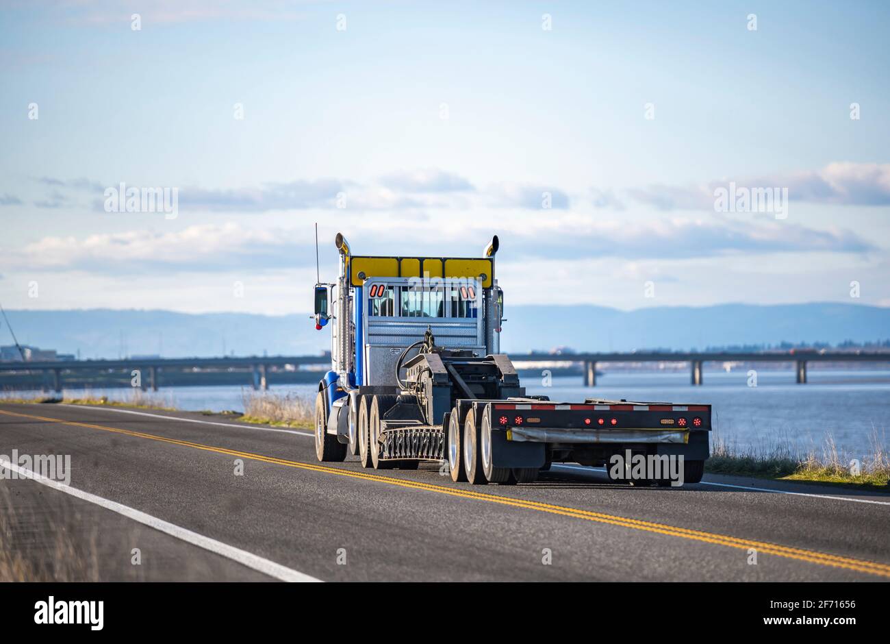 Classic blue American day cab big rig semi truck with oversize load ...