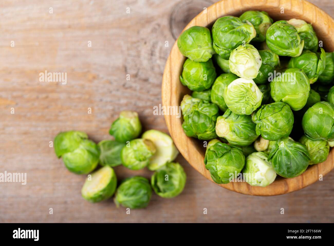 Fresh raw brussels sprouts in a bowl on a wooden table. Fresh harvest ...