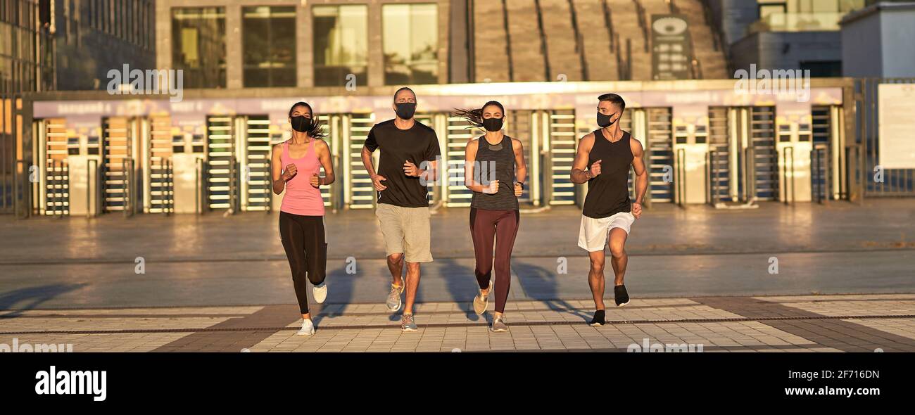 Four athletes in masks doing sports together outdoor Stock Photo - Alamy