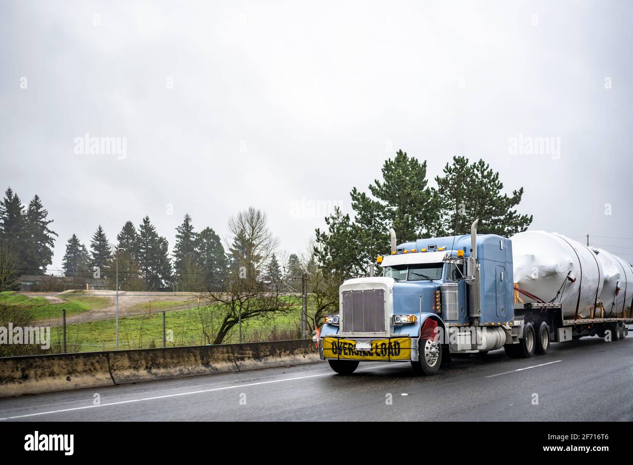Blue classic big rig semi truck with oversize load sign on the bumper ...