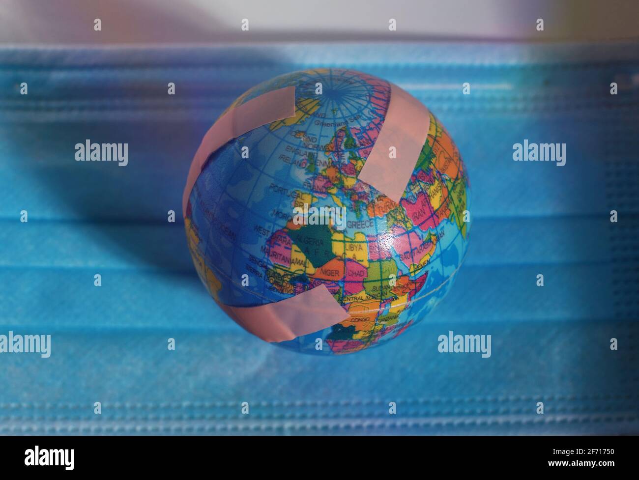Globe with plasters on a face mask . Concept of Corona Virus in the ...