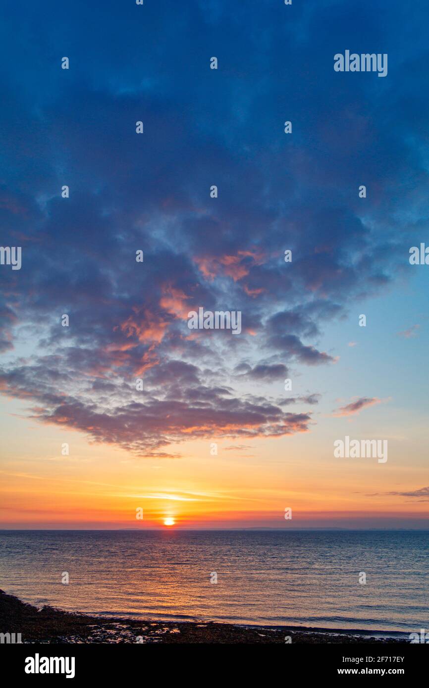 The setting sun lighting up the cloud cover Stock Photo - Alamy