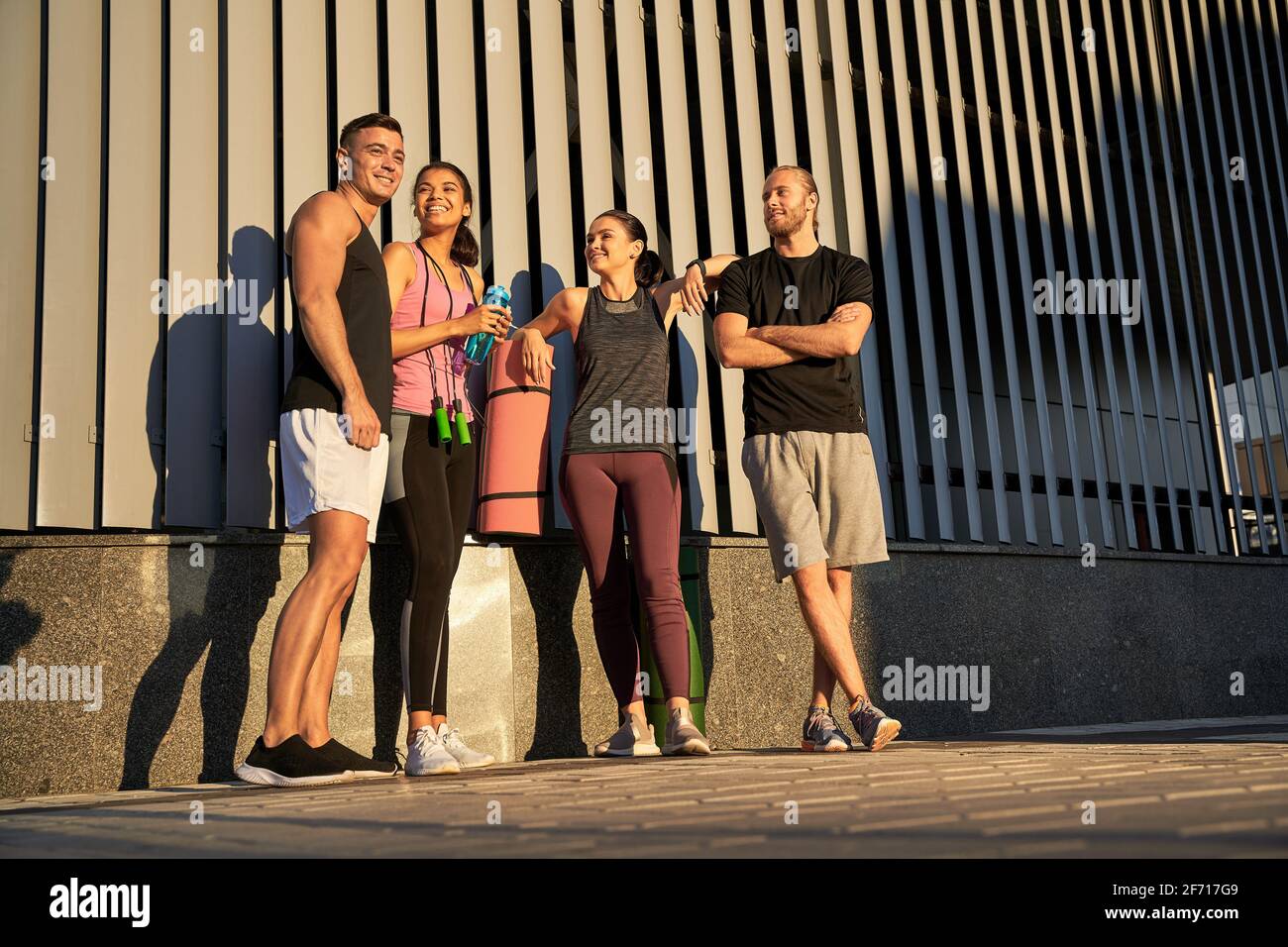 Four athletes standing in the street before training Stock Photo - Alamy